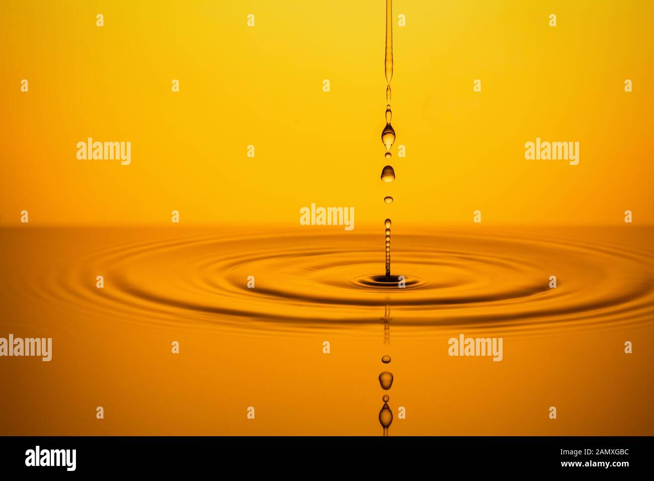 Ripple of the golden surface of yellow liquid with drops Stock Photo ...