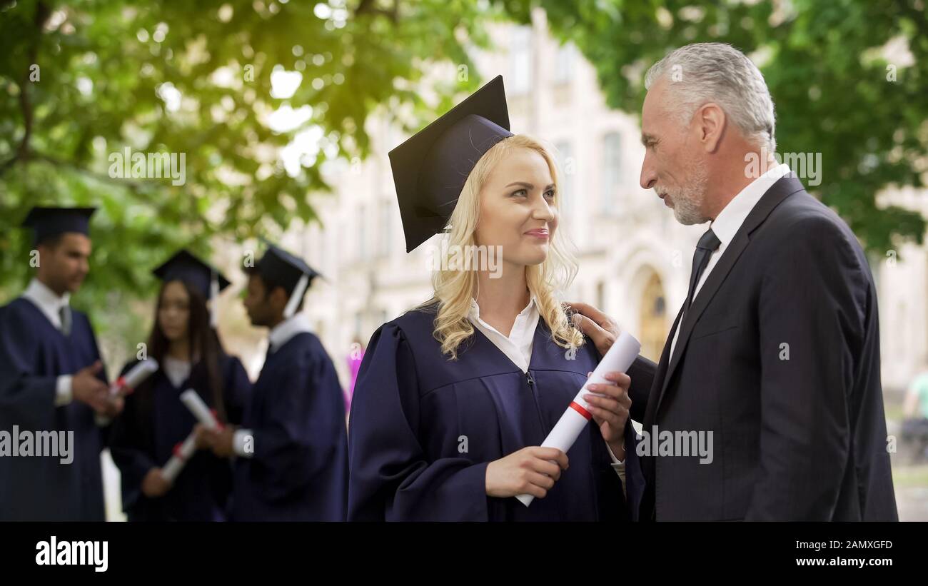Happy blonde graduate student rejoicing diploma with father, graduation ...