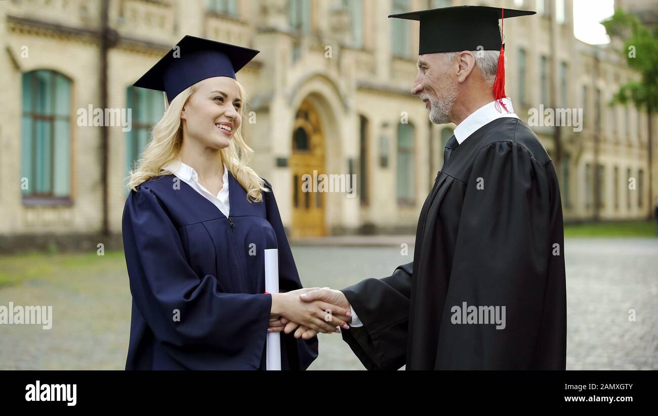 University chancellor giving diploma to student, congratulating and ...