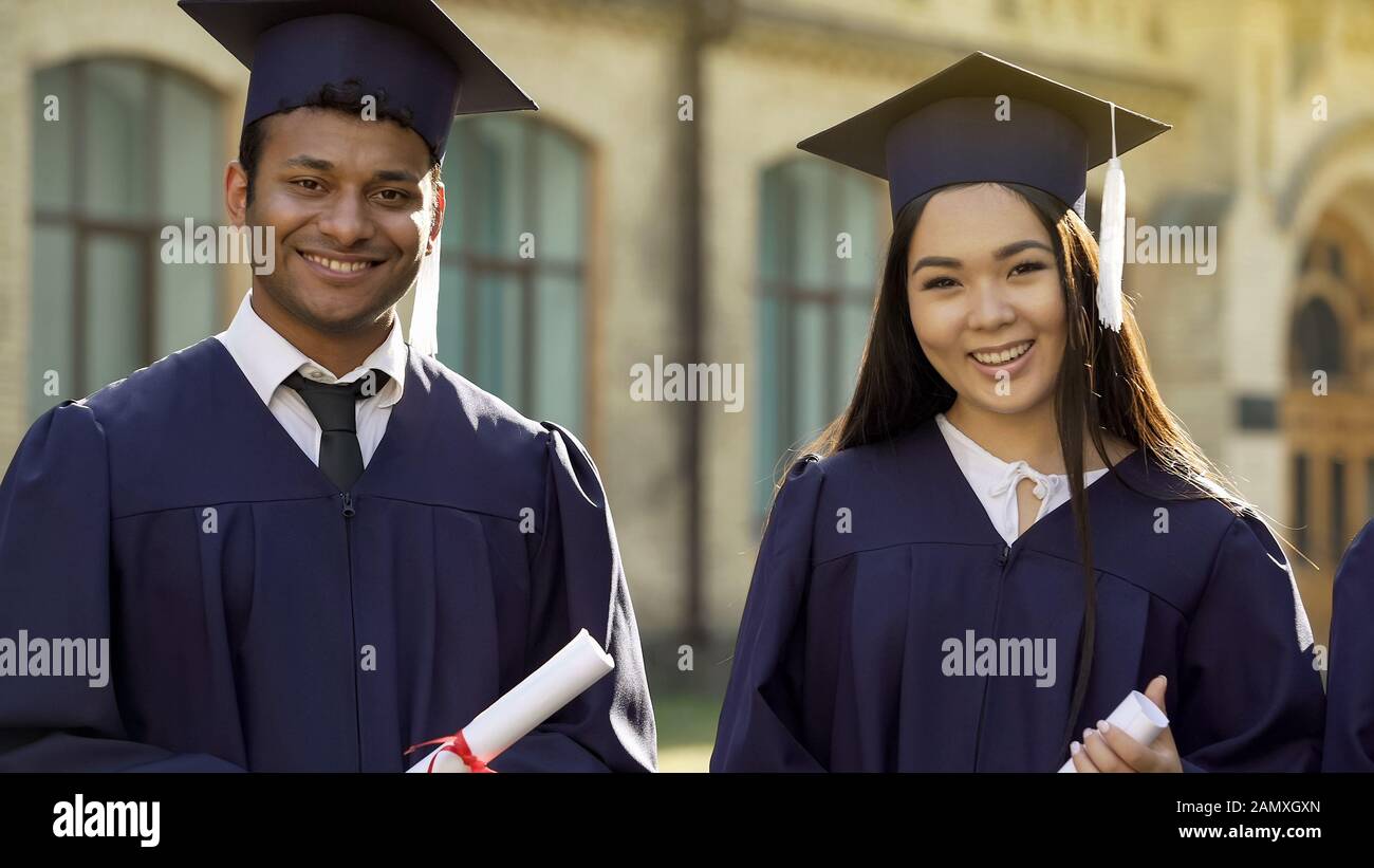 College student in graduation outfit with diplomas smiling, education ...