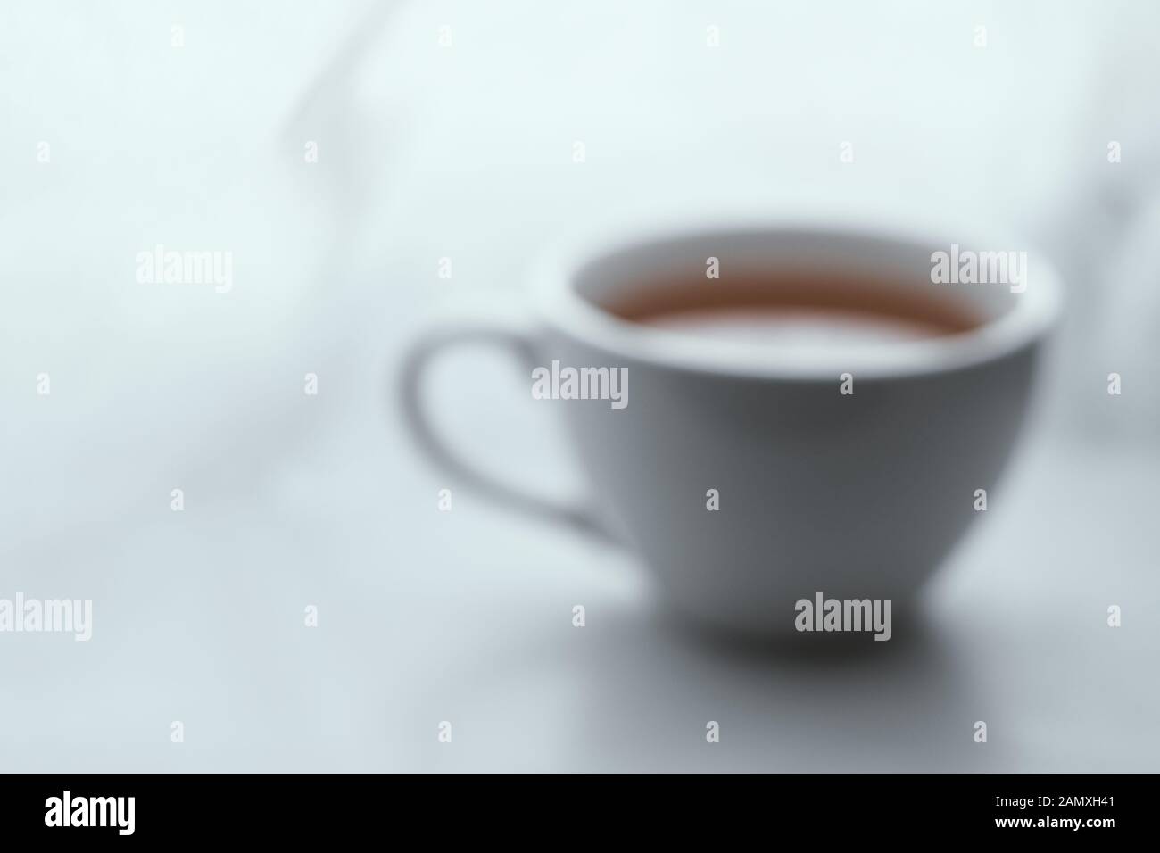 Blurred background image of simple white cup filled with tea on the ...