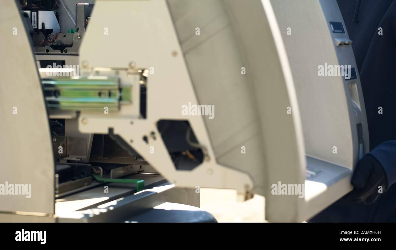 Bank employee opening ATM safe, checking breakdown, cash-in-transit ...