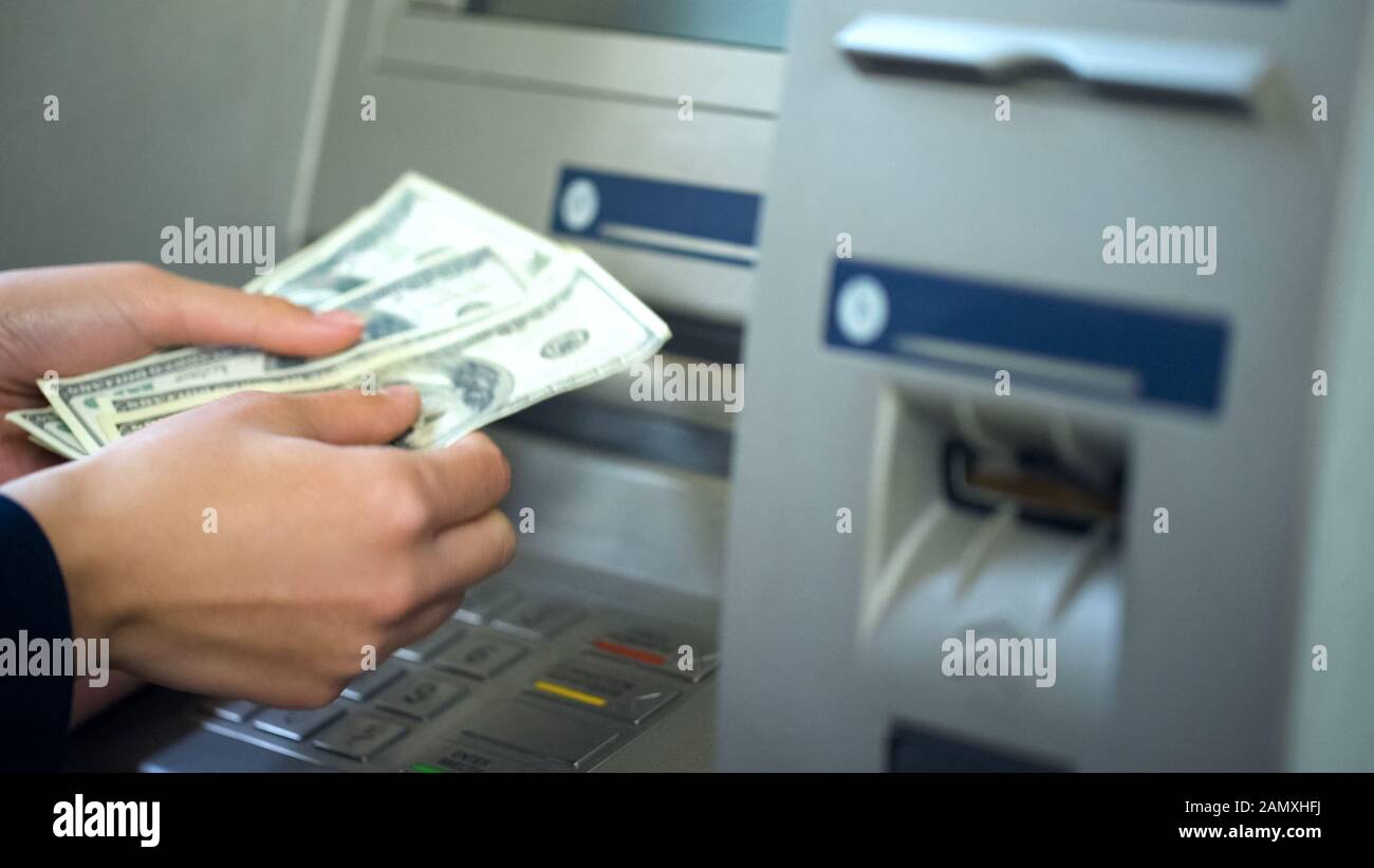 Woman counting dollars withdrawn from ATM, 24h service, easy banking ...