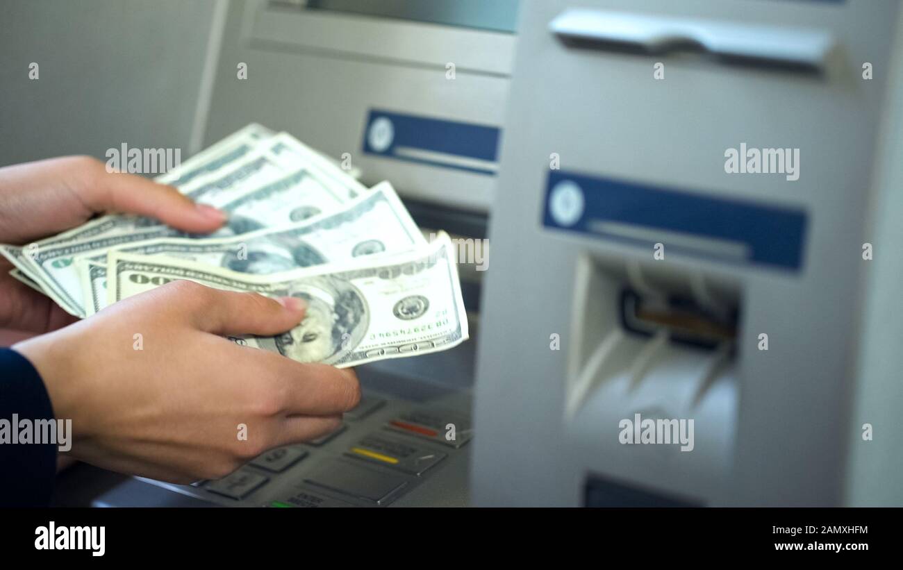 Female counting dollars withdrawn from ATM, 24h service, easy banking ...