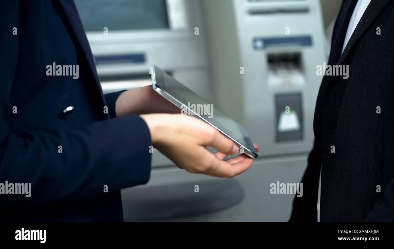 Assistant helping client with online banking application on tablet ...