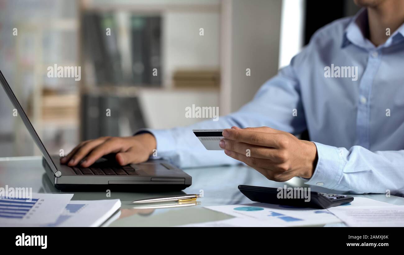 Administrator entering card number on office laptop, shopping online ...