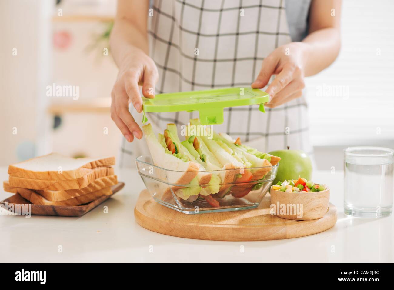 Mom preparing school snack or lunch for her daughter in home kitchen ...