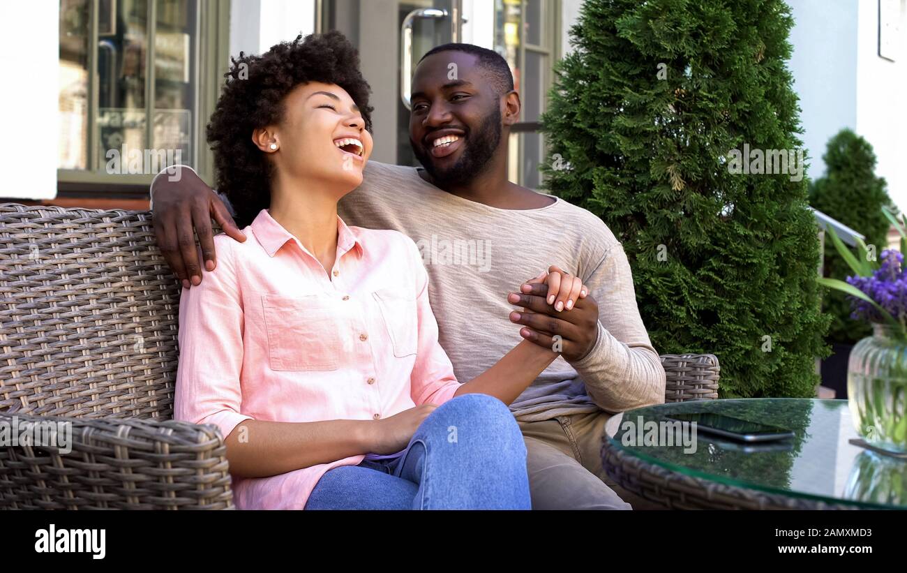 Happy afro-american couple enjoying romantic date, sitting cafe ...