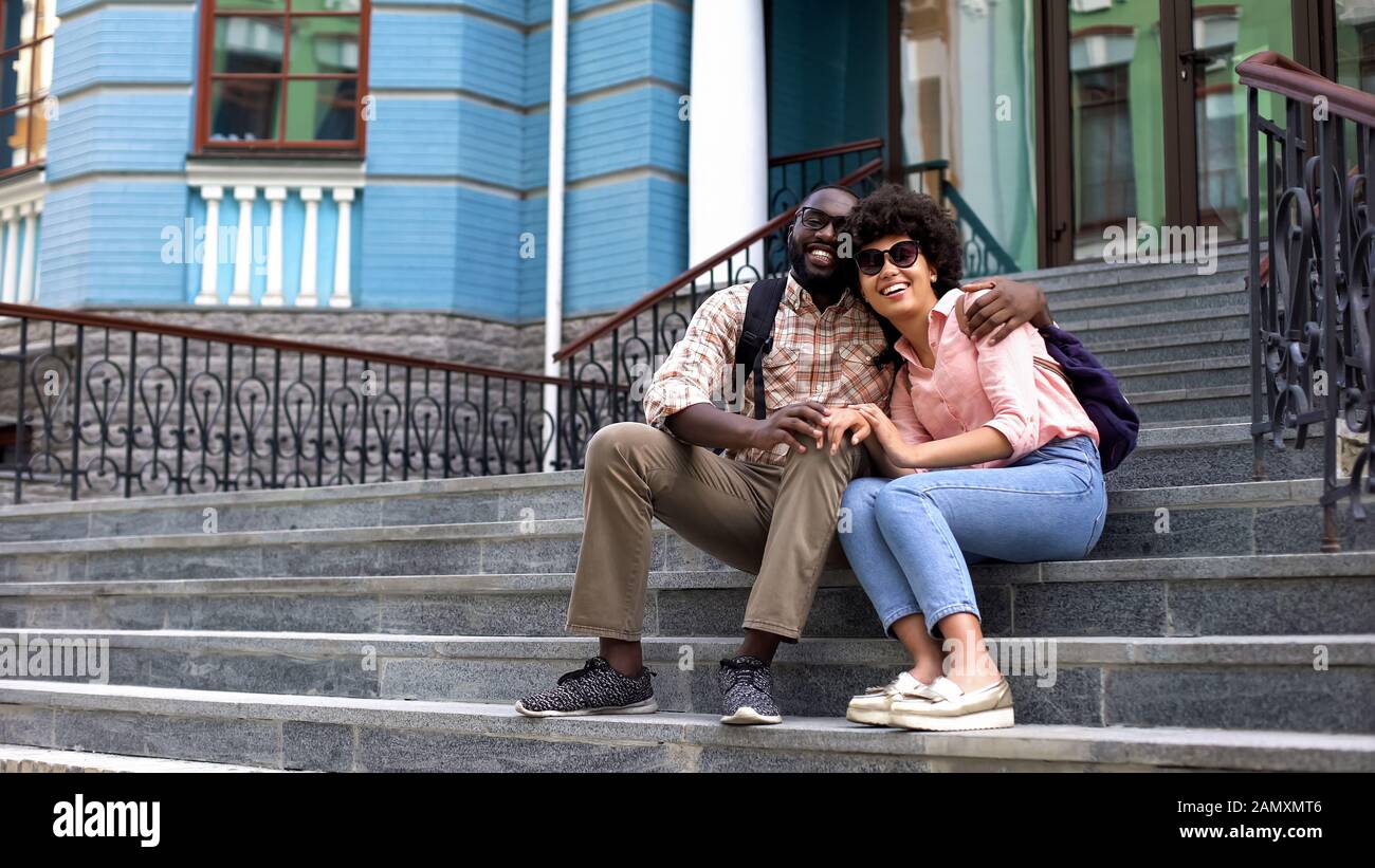 Happy student couple sitting hi-res stock photography and images - Alamy
