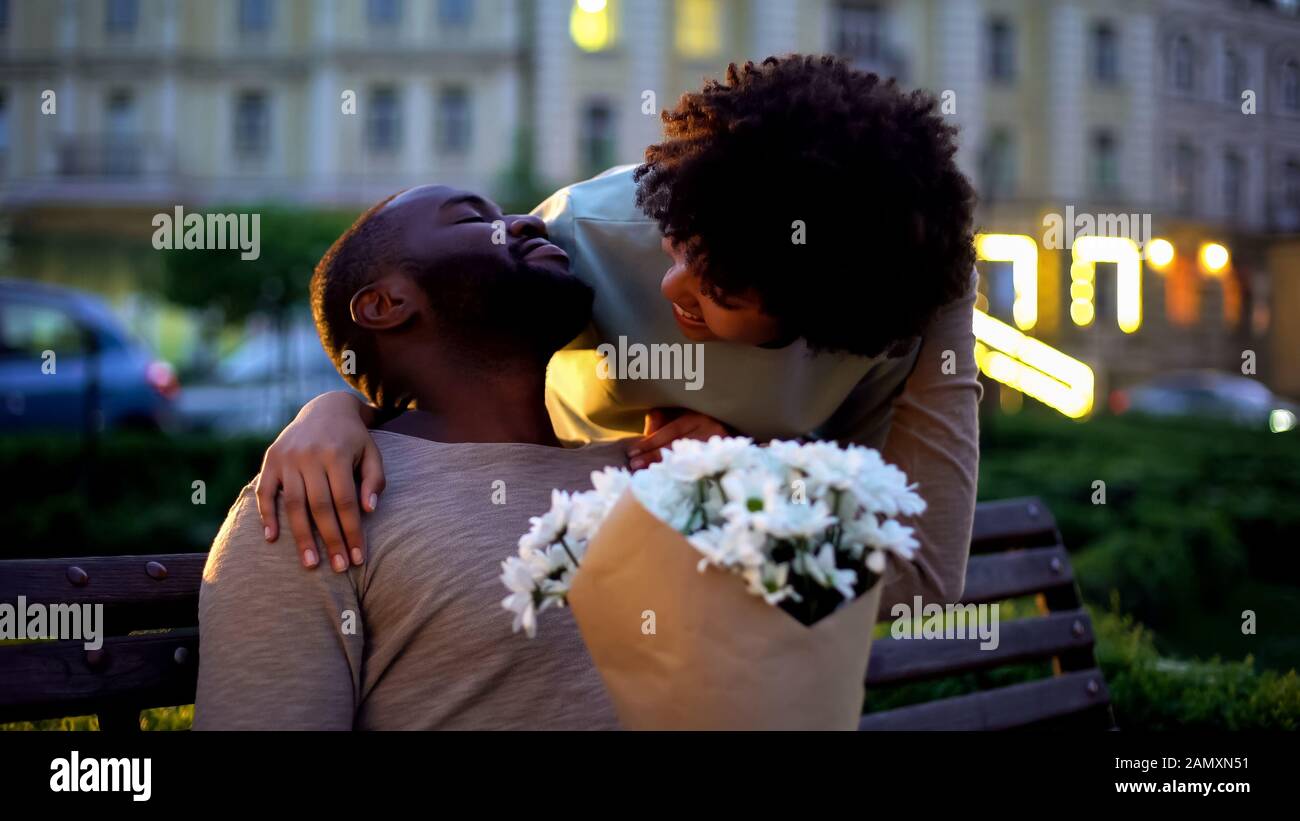 Lady embracing boyfriend, looking with love, holding flowers, romantic ...