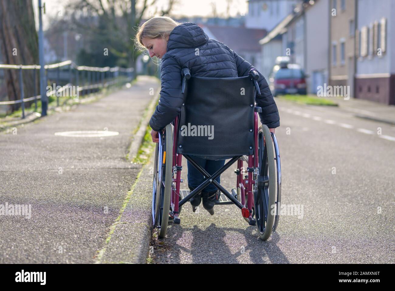 Handicapped woman using her wheelchair in a quiet back street in town ...