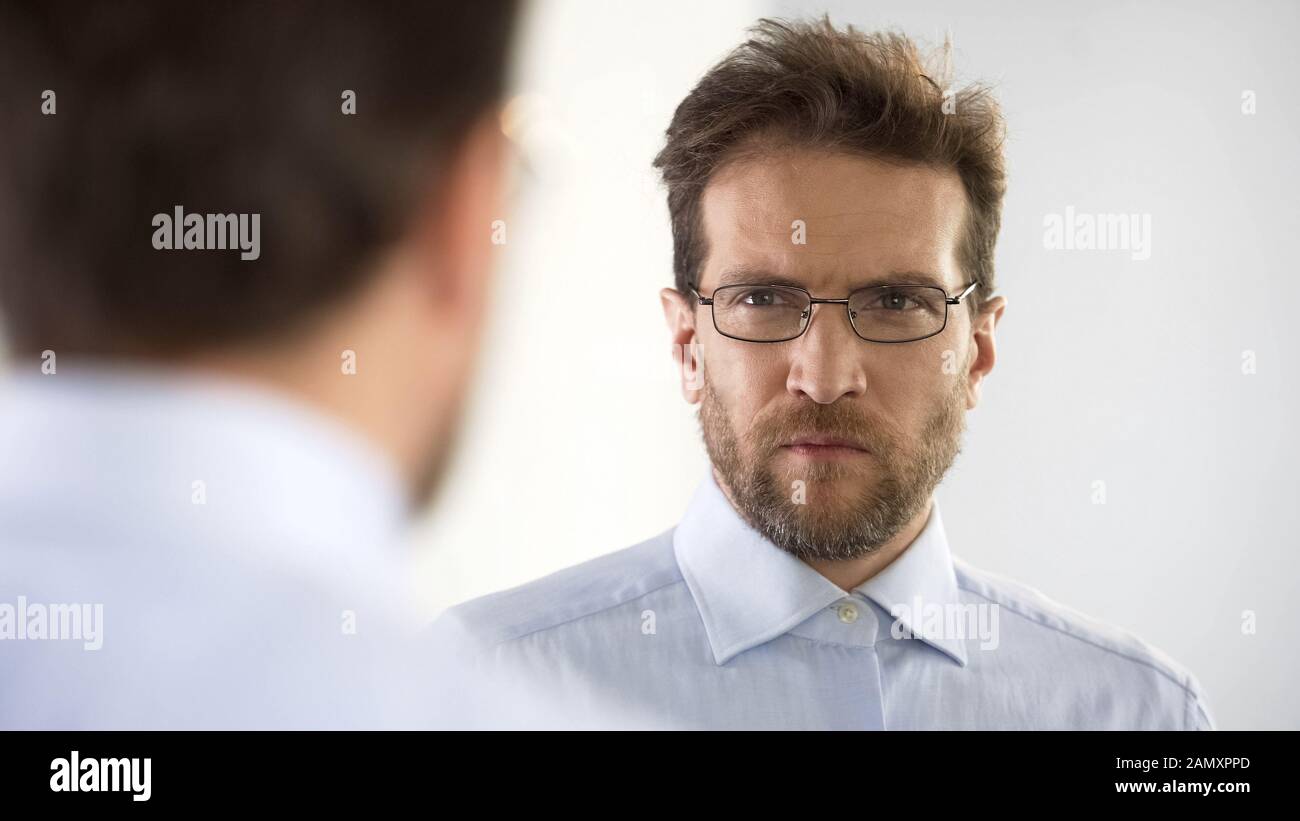 Man dissatisfied with his glasses and thinking about vision correction ...