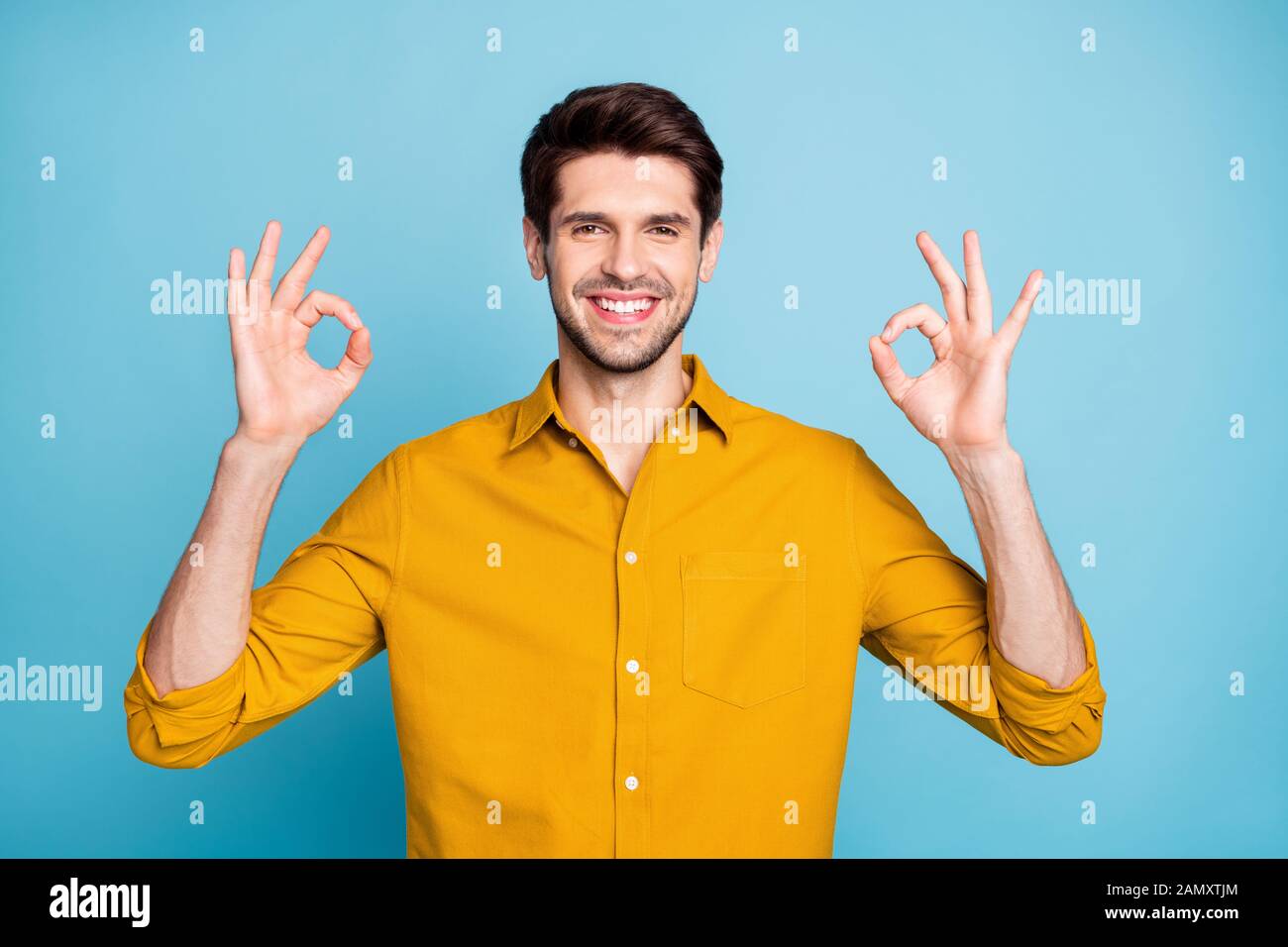 Photo of cheerful handsome man showing you double ok sign to say all is ...