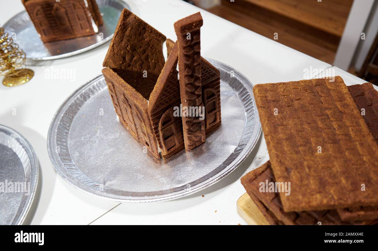 Gingerbread walls and chimney assembled with stack of roof sections ...