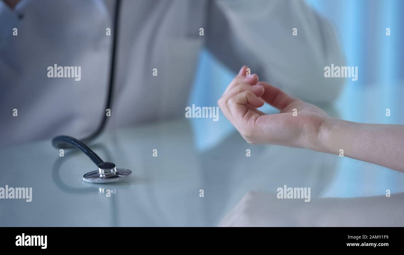 Hand of patient stretching to doctor, stethoscope on background clinic ...