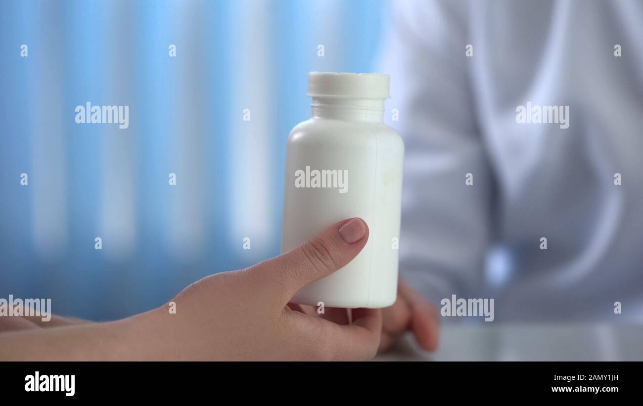 Doctor holding bottle pills prescribing hi-res stock photography and ...