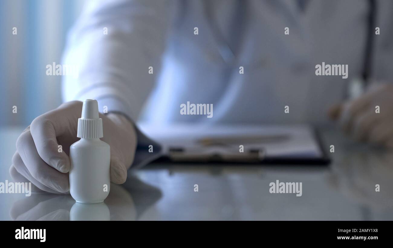 Family doctor giving nasal spray to patient, cold treatment, medicine ...