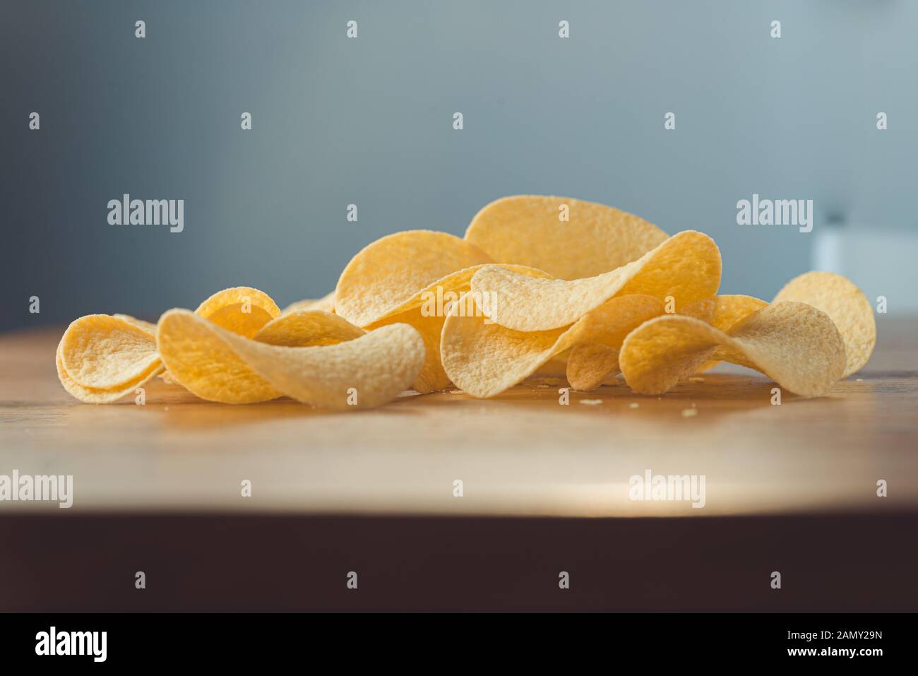 Delicious potato chips, laying on wooden table background Stock Photo ...