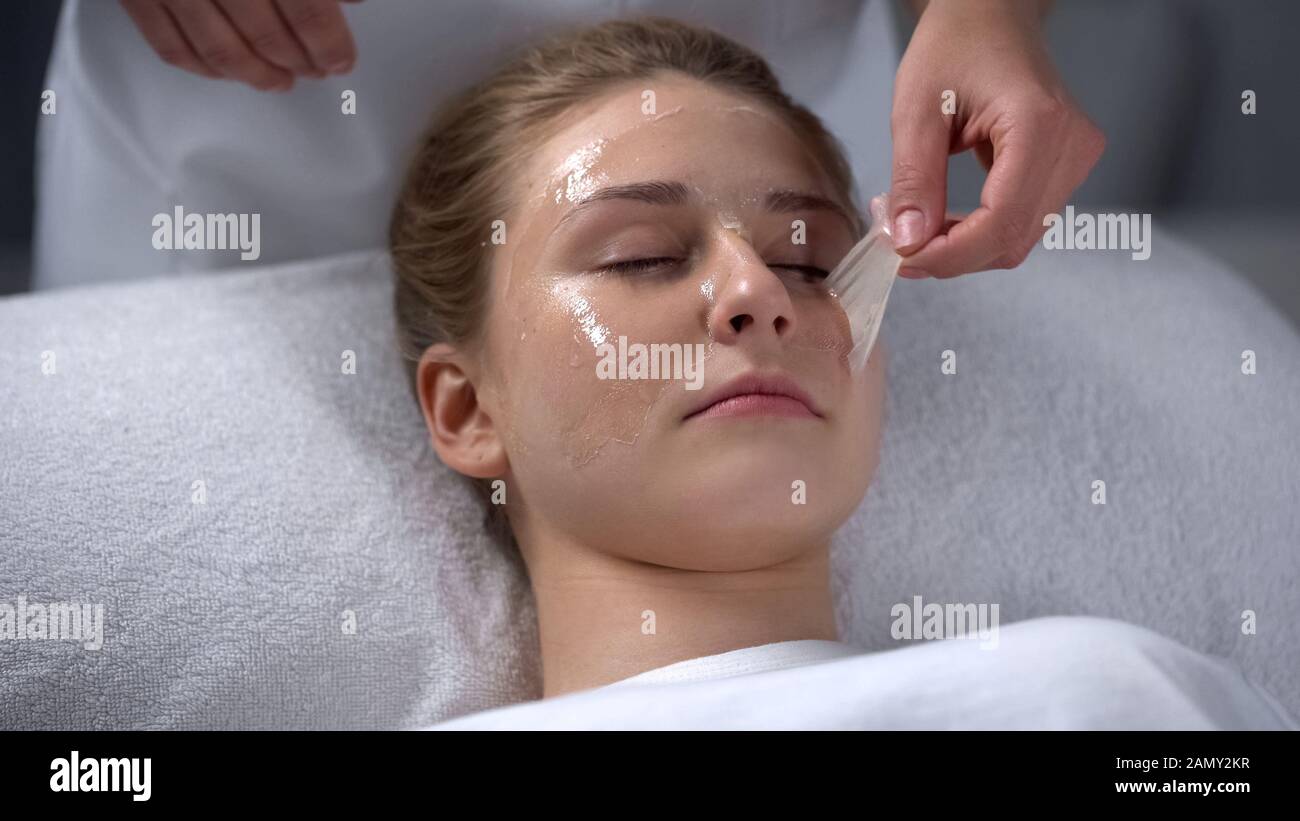 Beautician removing remains of mask from girls face, deep cleaning of ...