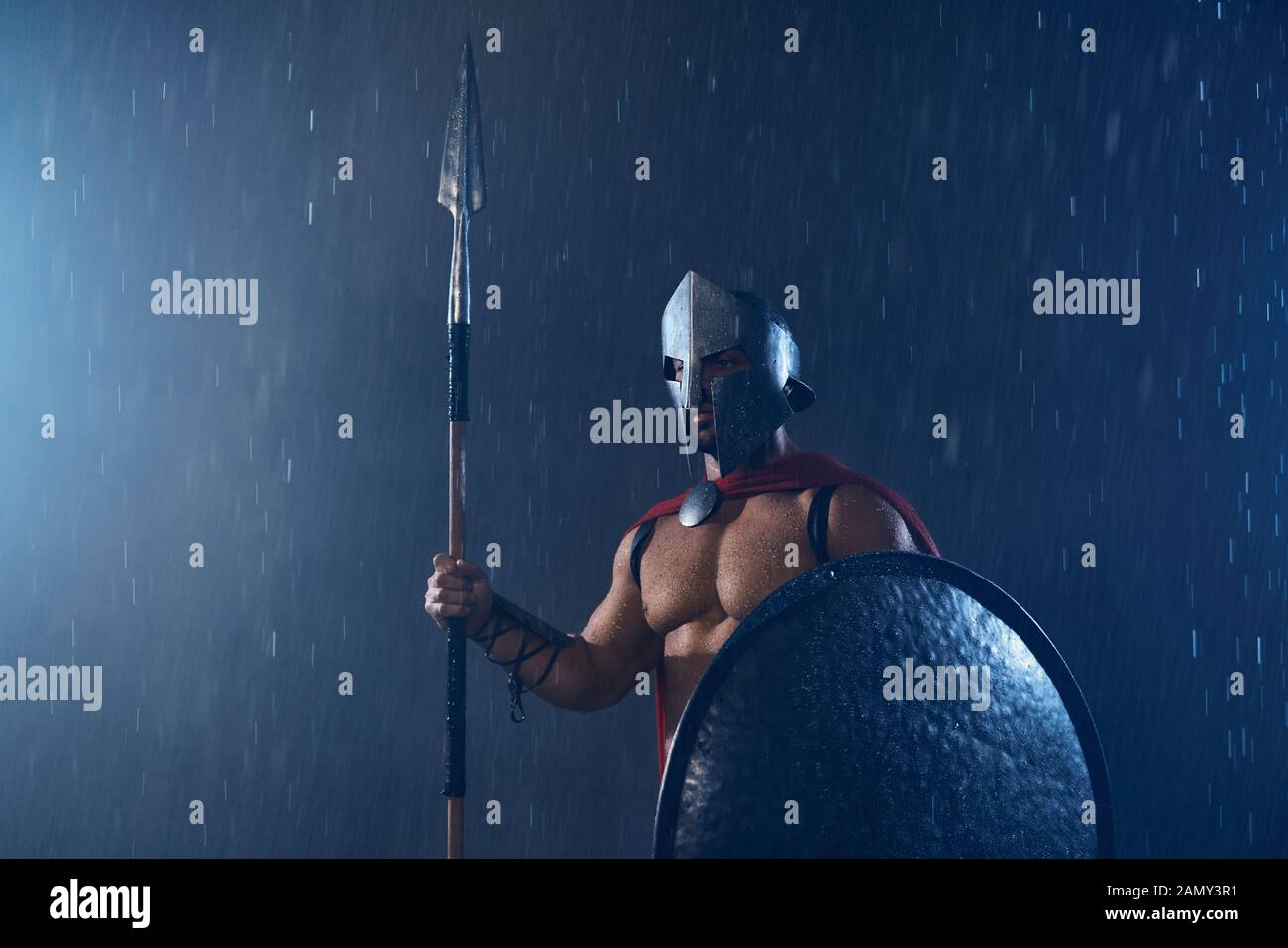 Portrait of spartan warrior standing outdoors with spear and shield in ...