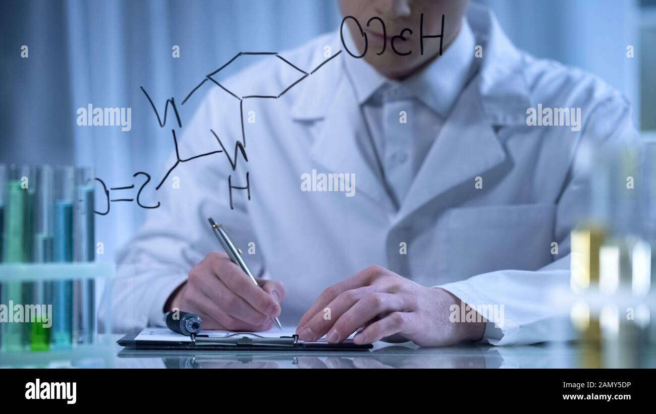 Chemist writing formula on glass and cardboard folder, research in ...
