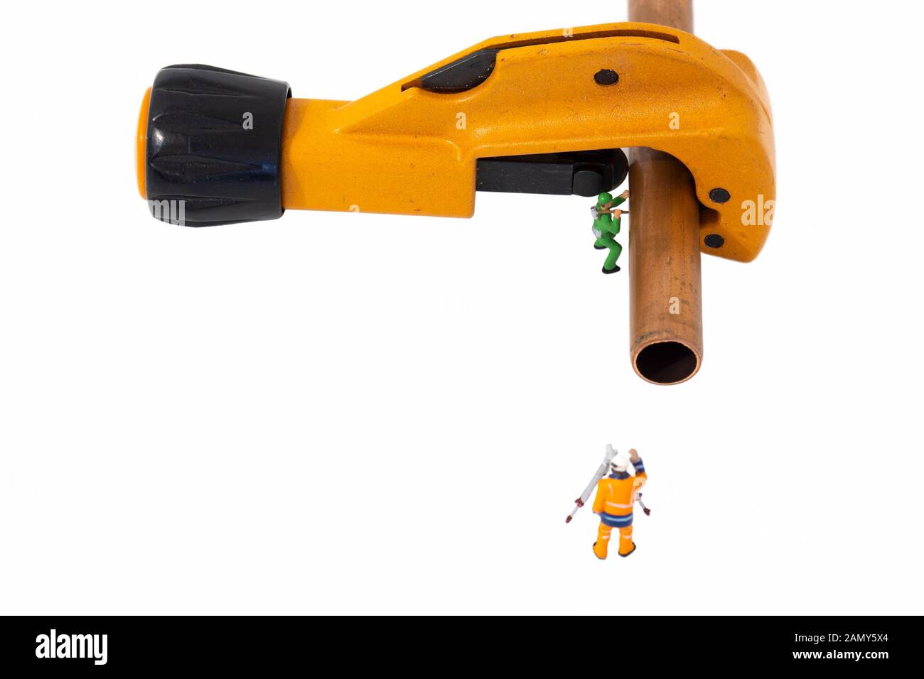 Miniature scale model construction workers with a copper pipe and a ...