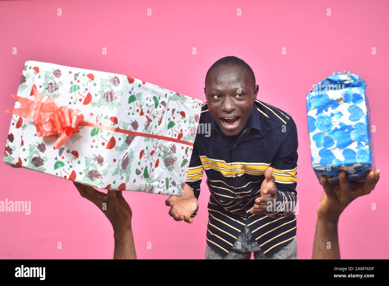 handsome young black man feeling excited with someone holding presents ...