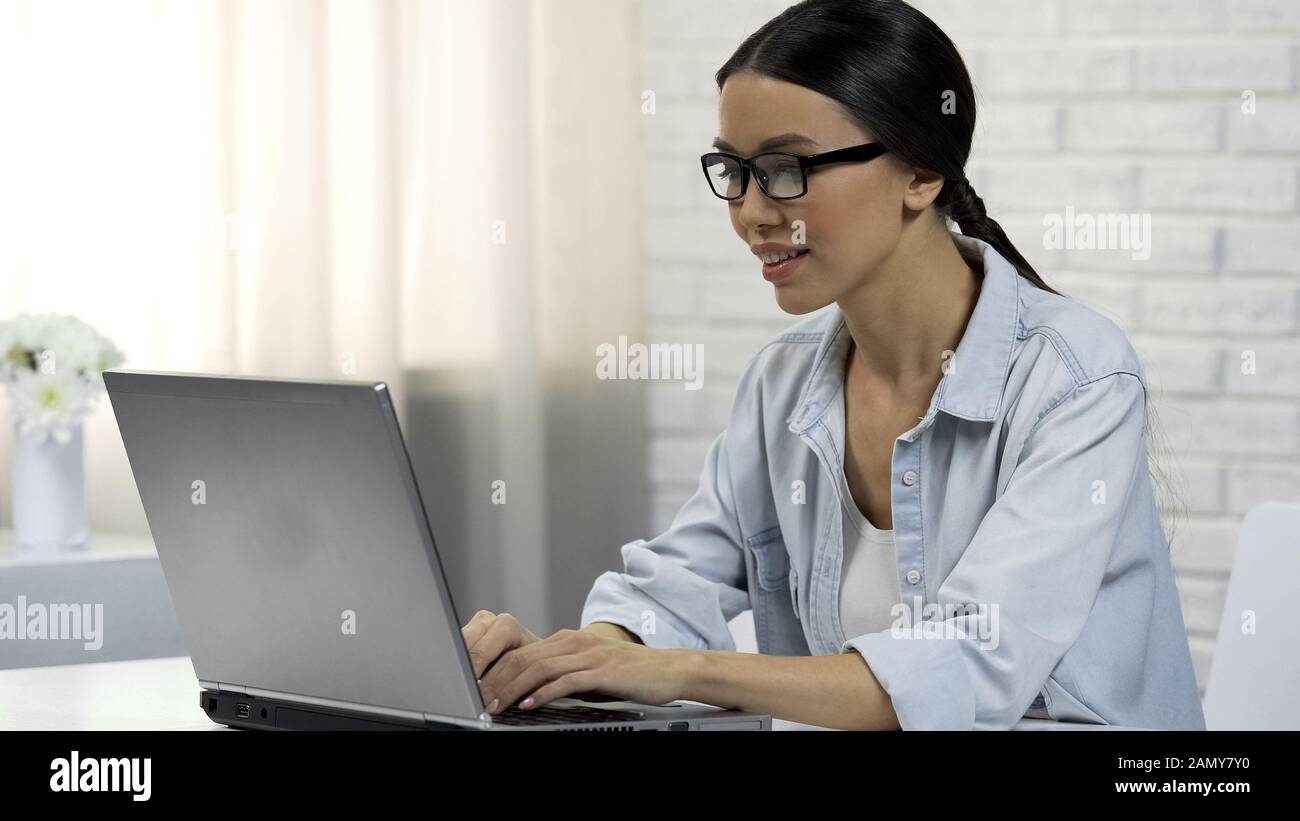Woman typing on laptop chatting in social network, answering messages ...