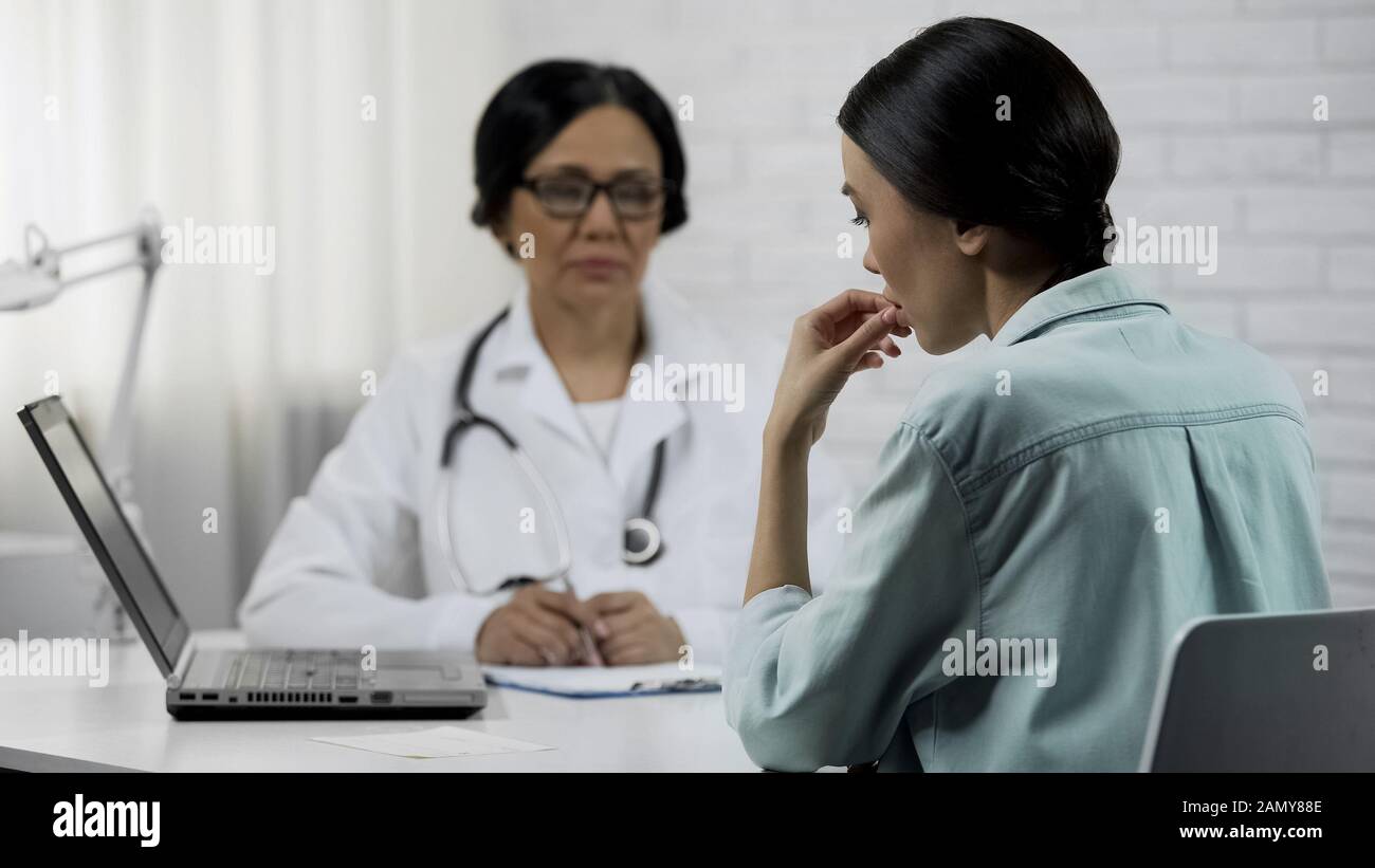 Practitioner informing young patient about bad diagnosis, incurable ...