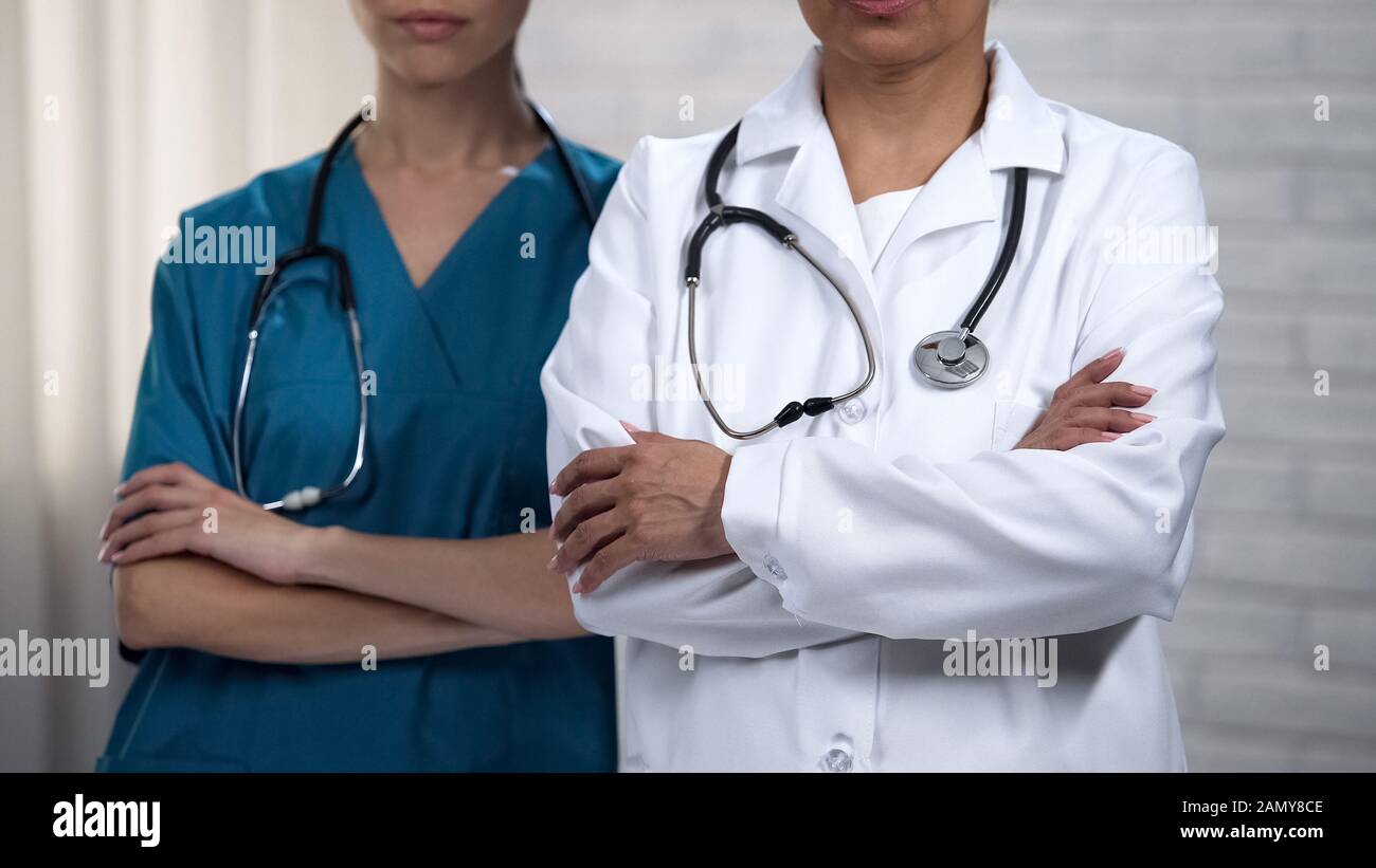 Medical co-workers crossing hands, professionals always ready to help ...