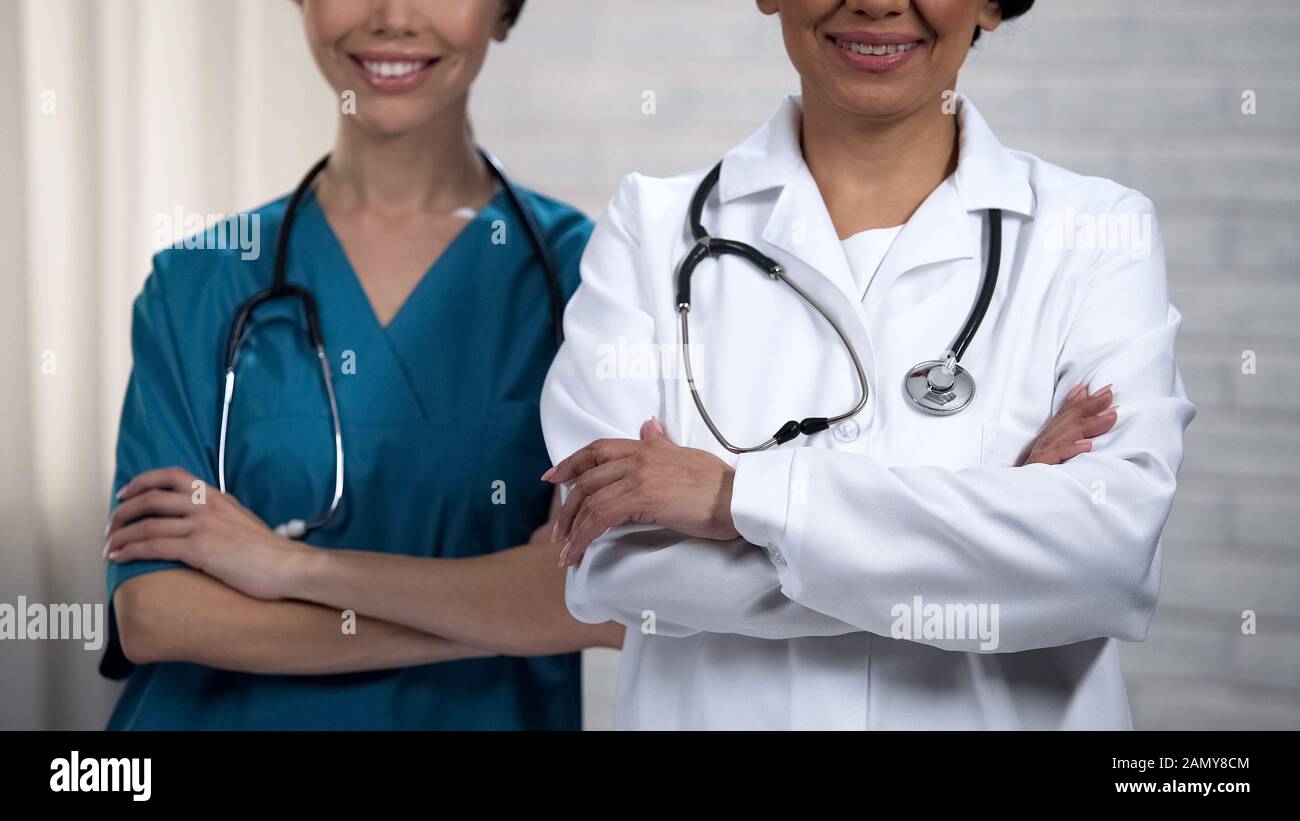 Physicians smiling and crossing hands, highly qualified help of medical ...