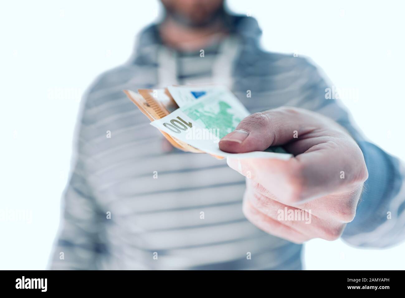 midsection of man holding banknotes in his hand handing it over to ...