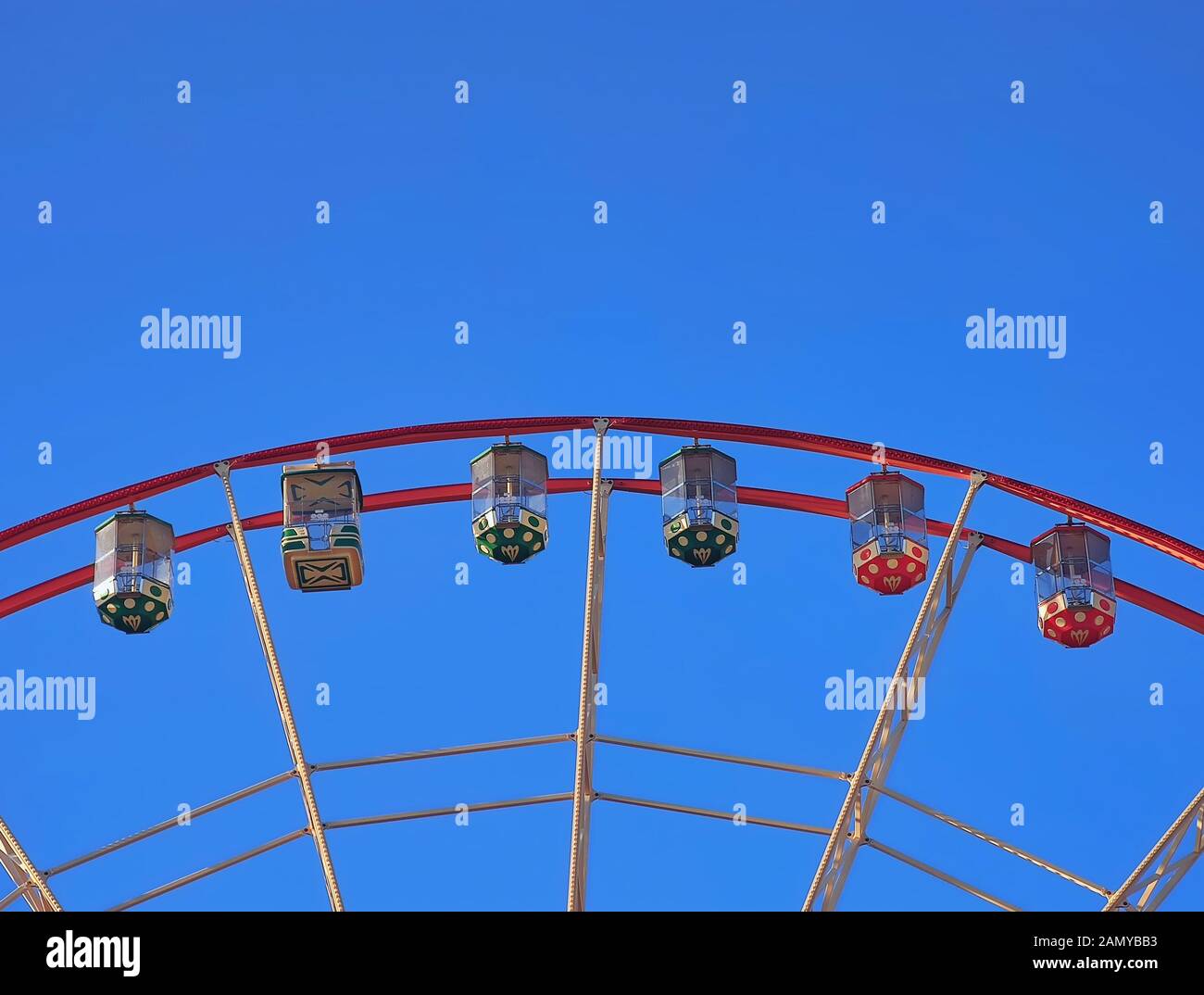 Close-up of section of colorful bright red ferris wheel with few empty ...