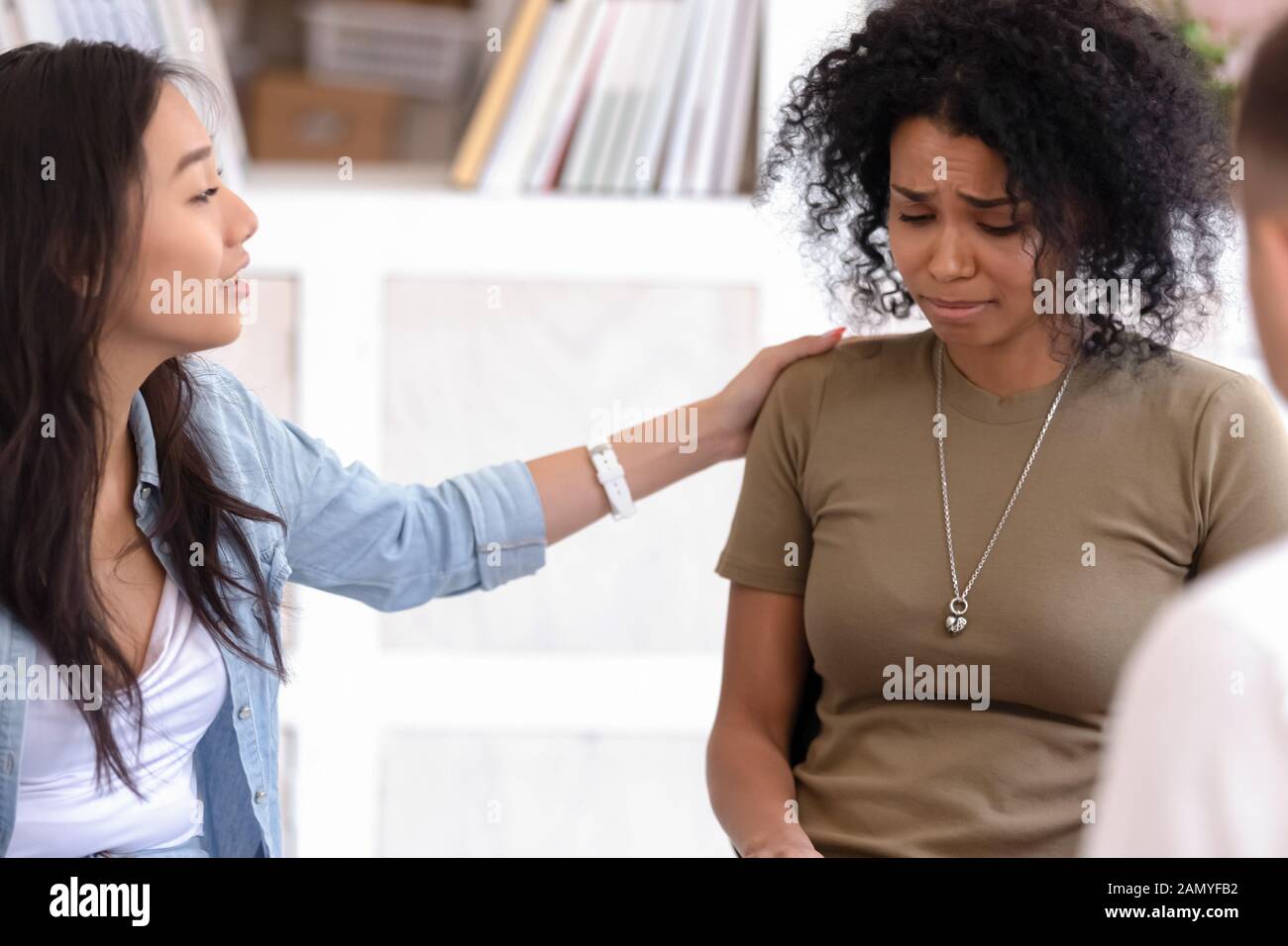 Asian girl hug support crying friend at group session Stock Photo - Alamy