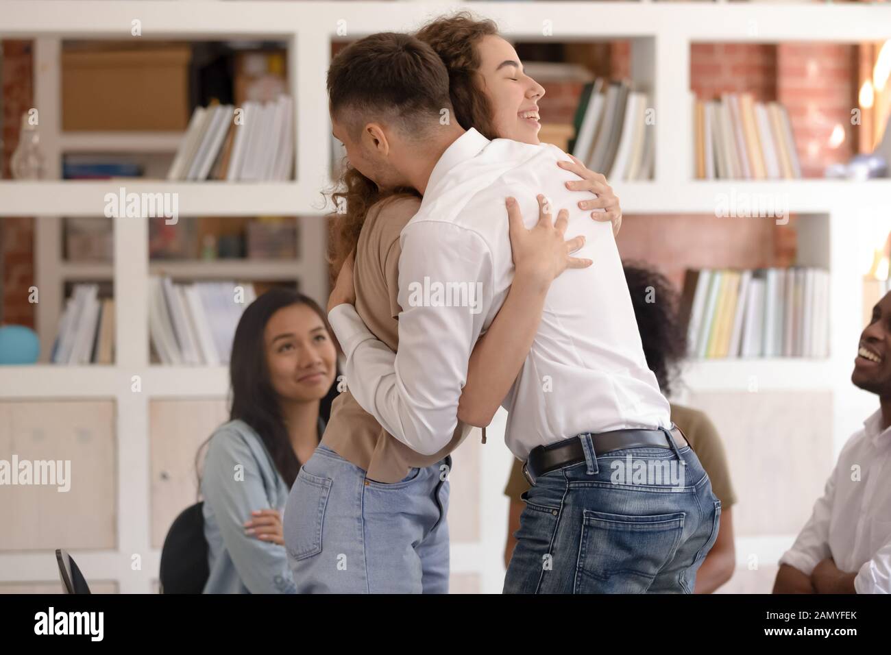 People stand hugging showing support at psychological group session ...