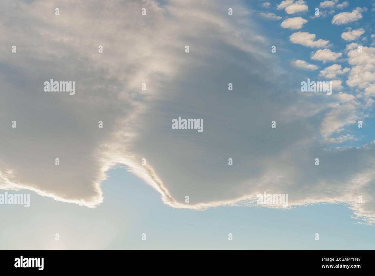 Beautiful cirrus and cumulus clouds on a bright blue sky lit by ...
