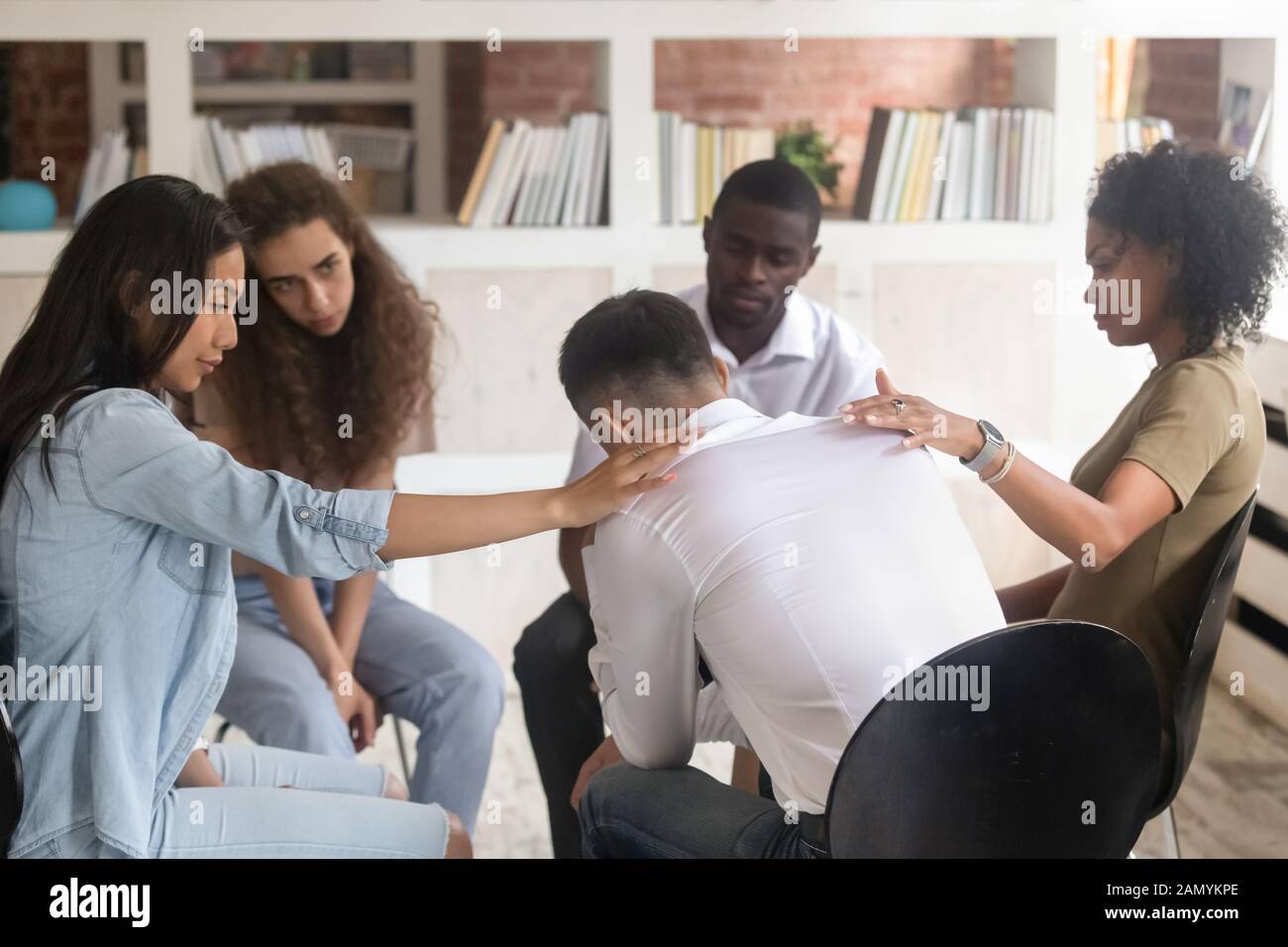 Diverse people hug support depressed man at group therapy Stock Photo ...