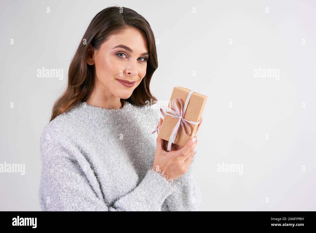 Portrait of smiling woman showing the gift in studio shot Stock Photo ...