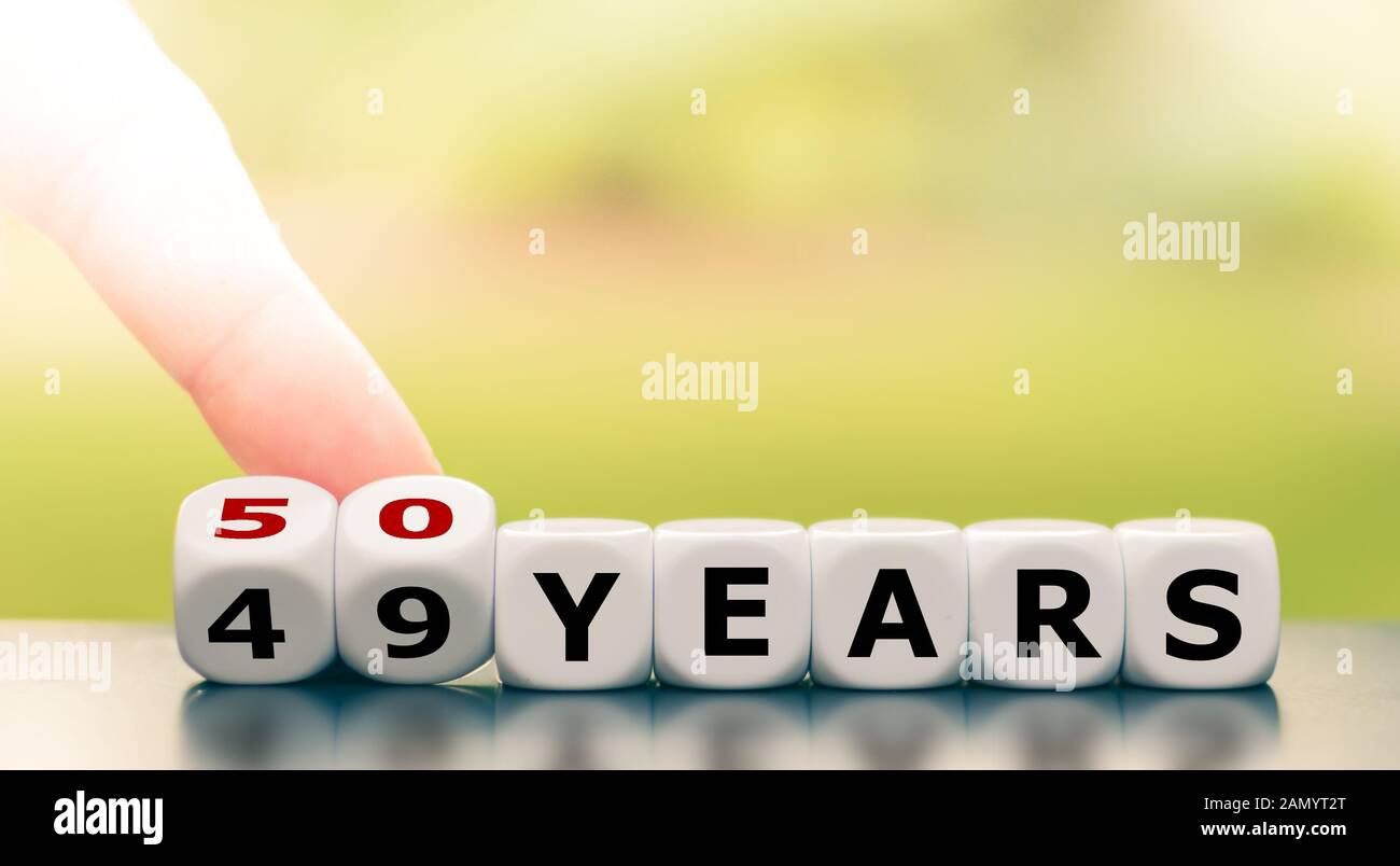 Symbol for turning 50 years old. Hand turns a dice and changes the ...