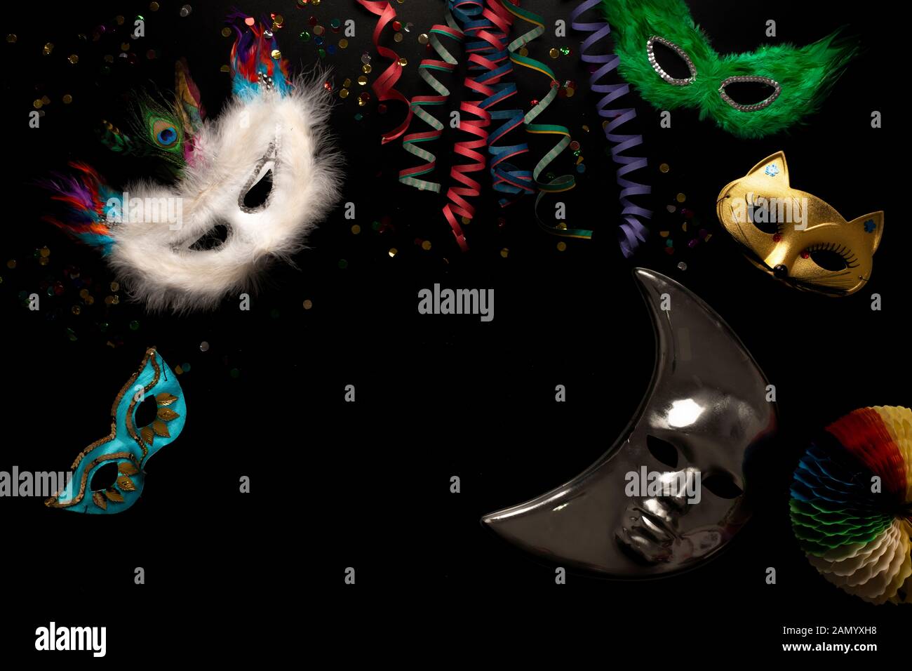Carnival objects on a black background. Coiled streamers, masks ...
