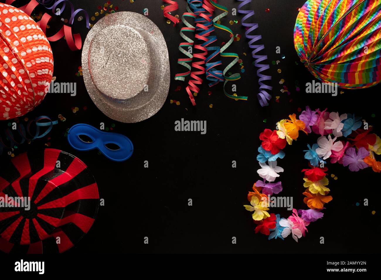 Carnival objects on a black background. Coiled streamers, hats ...