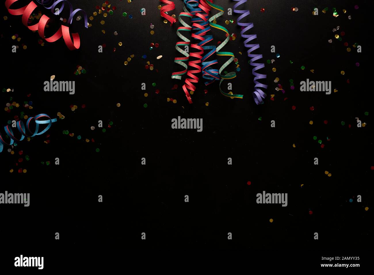 Carnival objects on a black background. Coiled streamers, and confetti ...