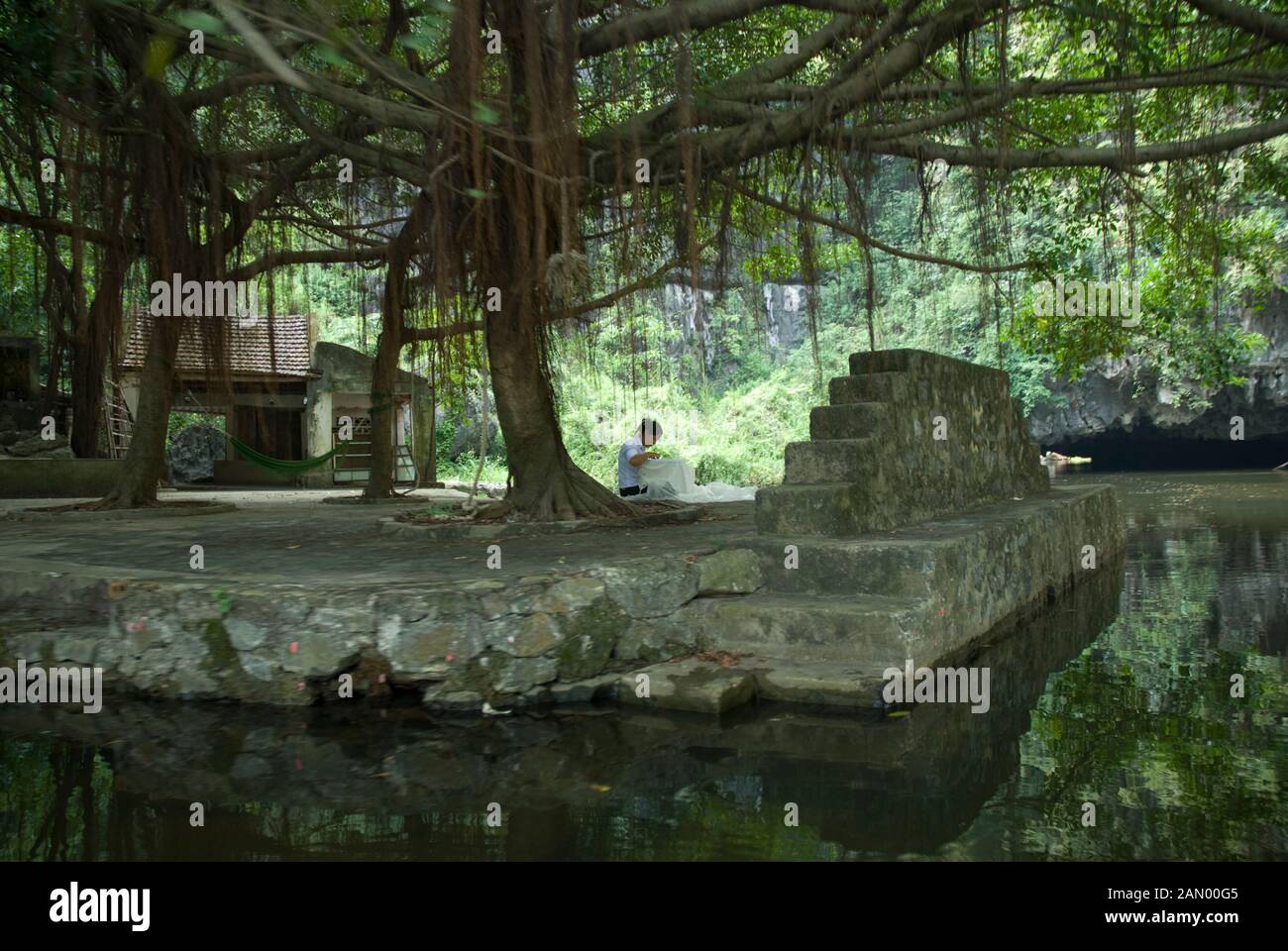 Woman darning under tree by waterway, near Perfume Pagoda, Chua Huong ...