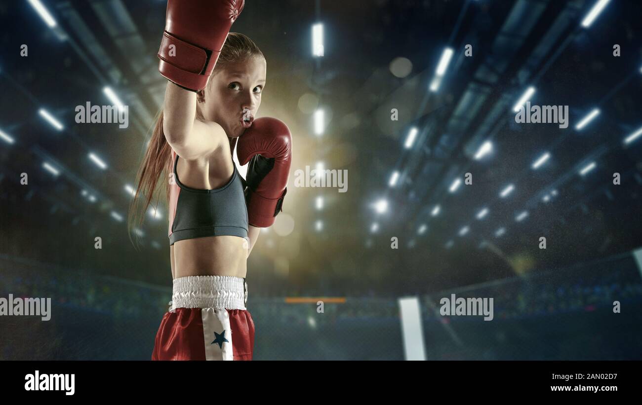 Stronger then ever. Young female kickboxing fighter training in the gym ...
