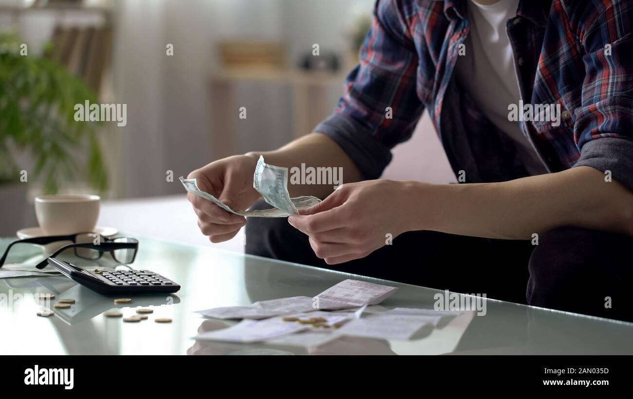 Man calculating money left to next salary, poor male saving his money ...