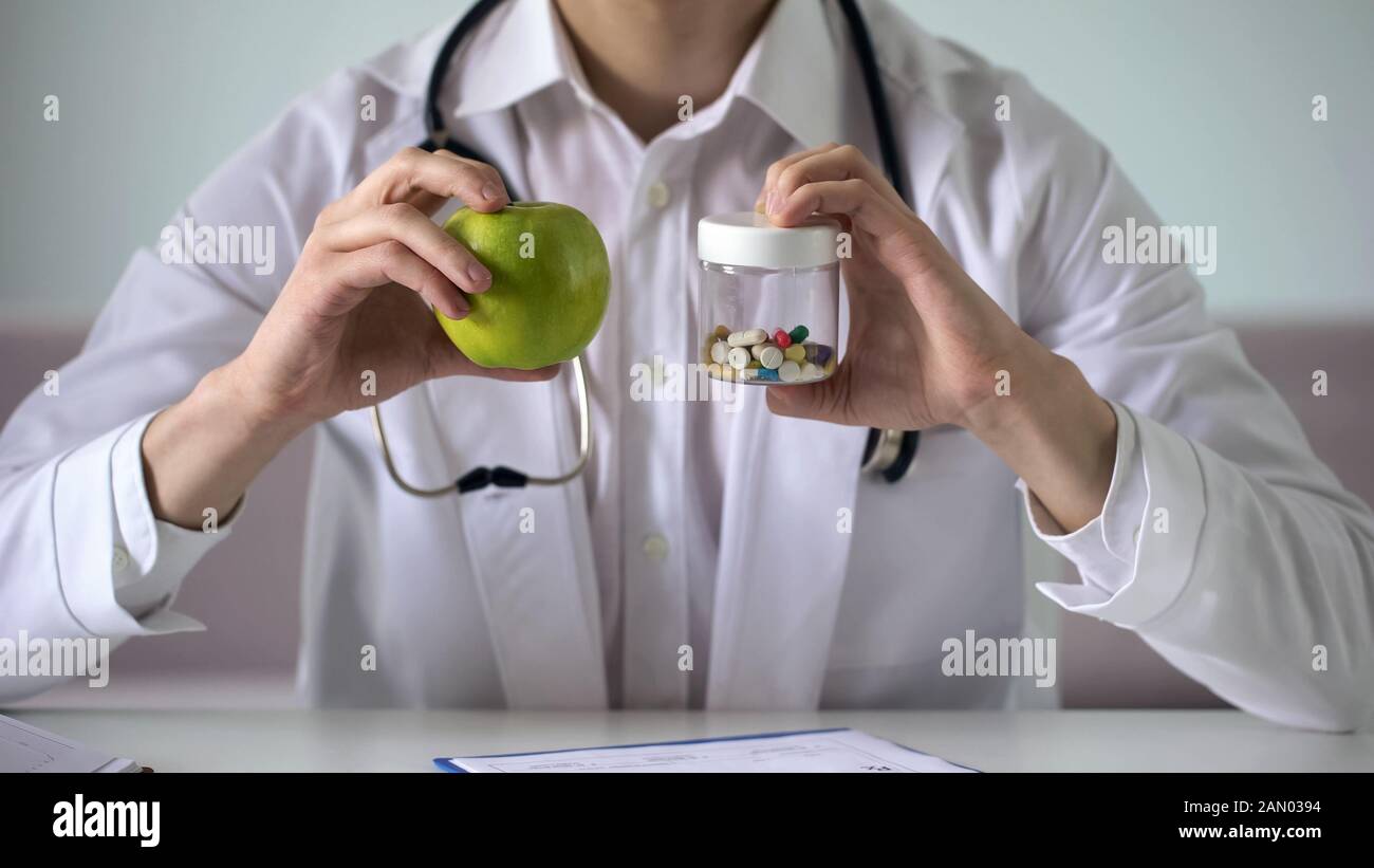 Doctor explaining vitamins benefits, comparing with fresh apple ...