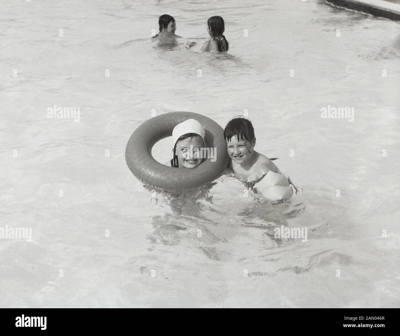 1980s Historical Two Children In A Swimming Pool With The Girl s 1980s-historical-two-children-in-a-swimming-pool-with-the-girl-s