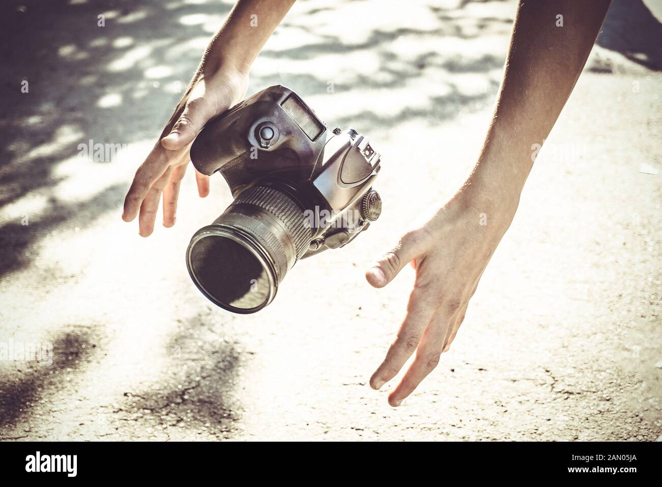 The photographer dropped the camera and catches it with his hands, the ...
