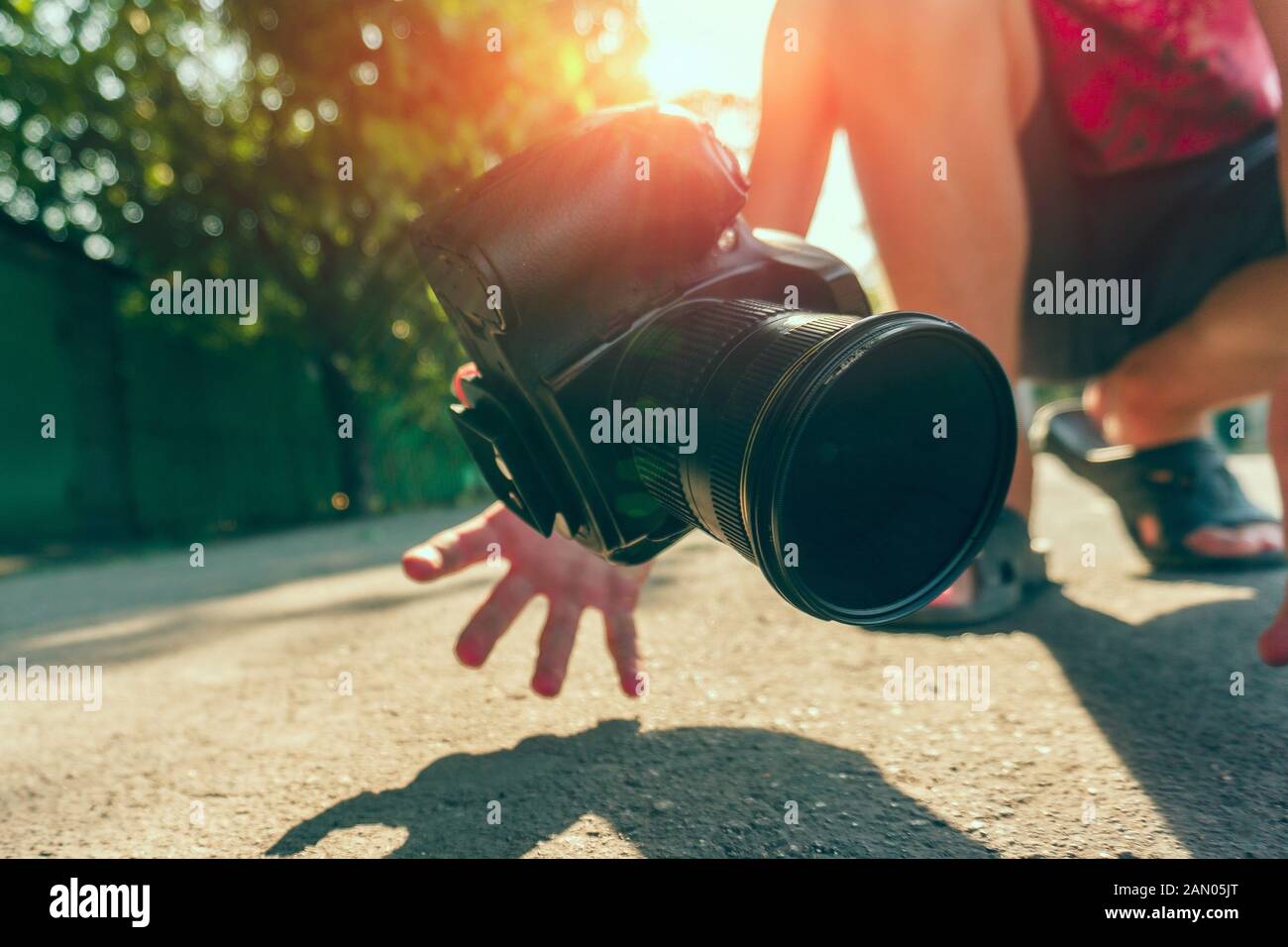 The photographer dropped the camera and catches it with his hands, the ...