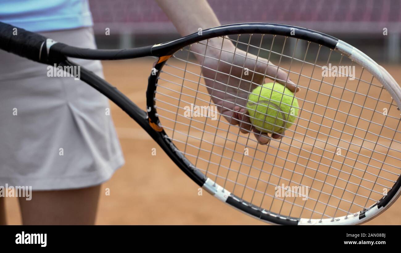 Hands of lady player holding racket and preparing to serve tennis ball ...